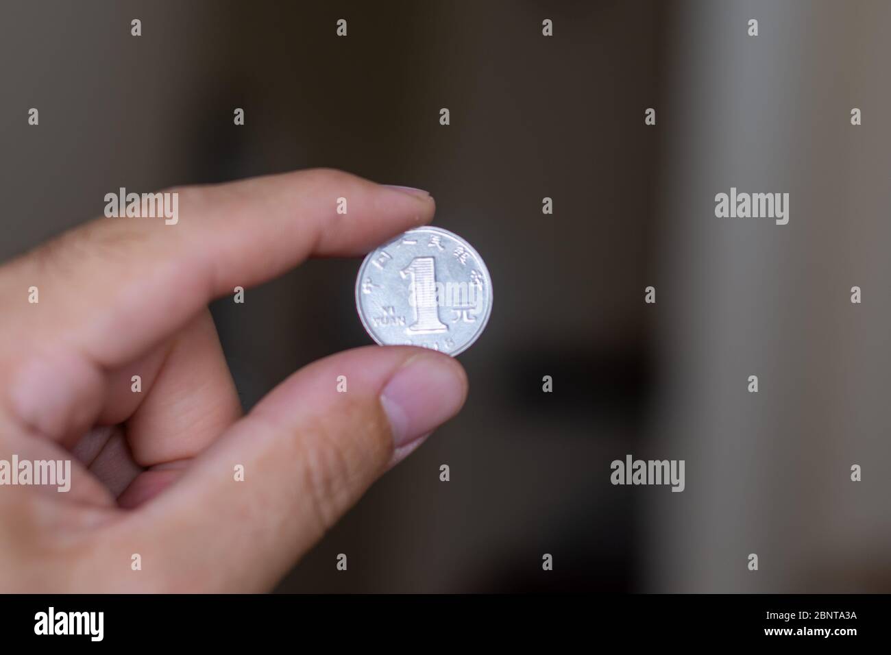 Persons hand holding out a one reminbi (RMB) or Yuan, the Currency of ...