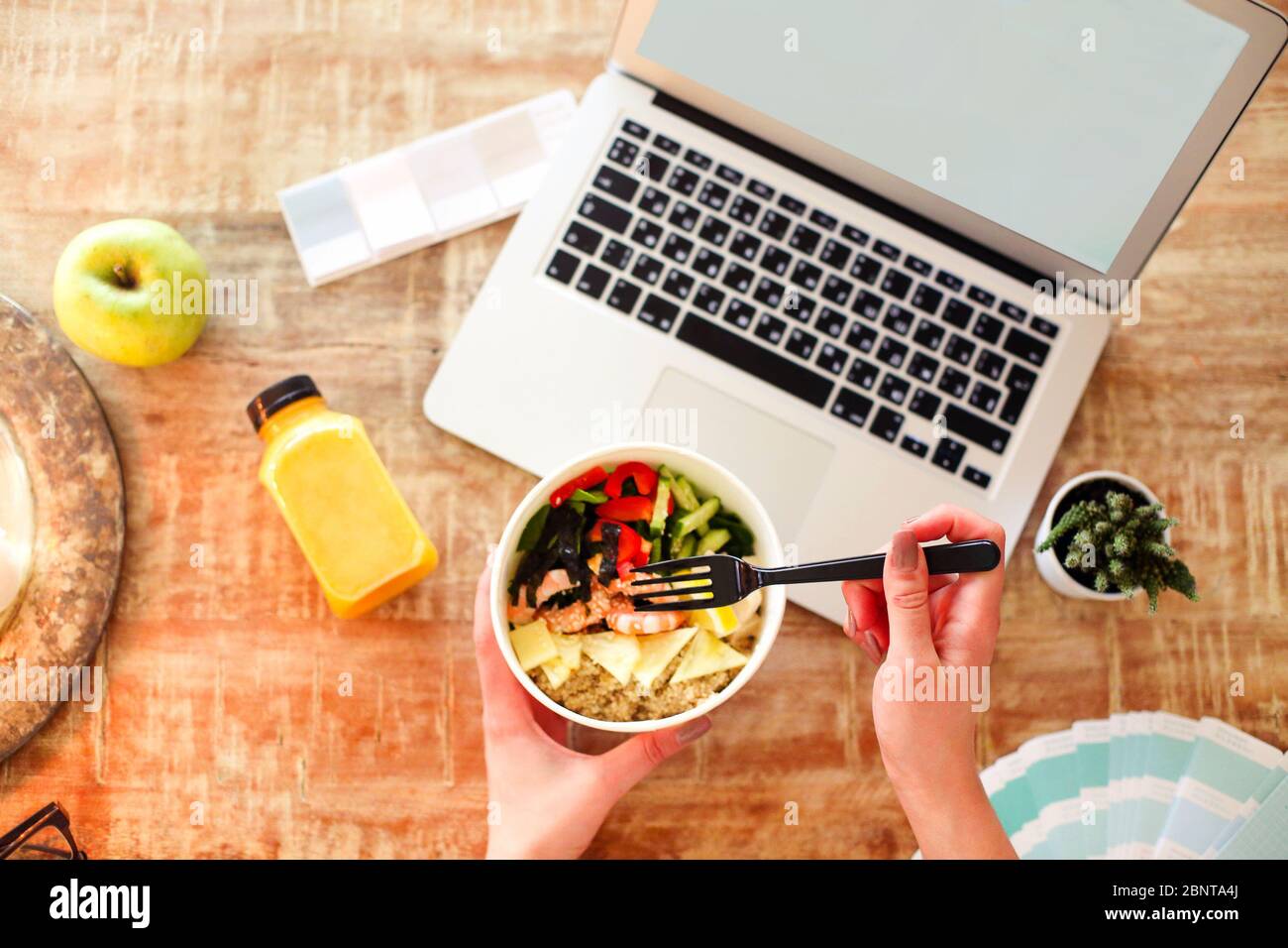 Overhead anonymous woman eating healthy dish for lunch over table with ...
