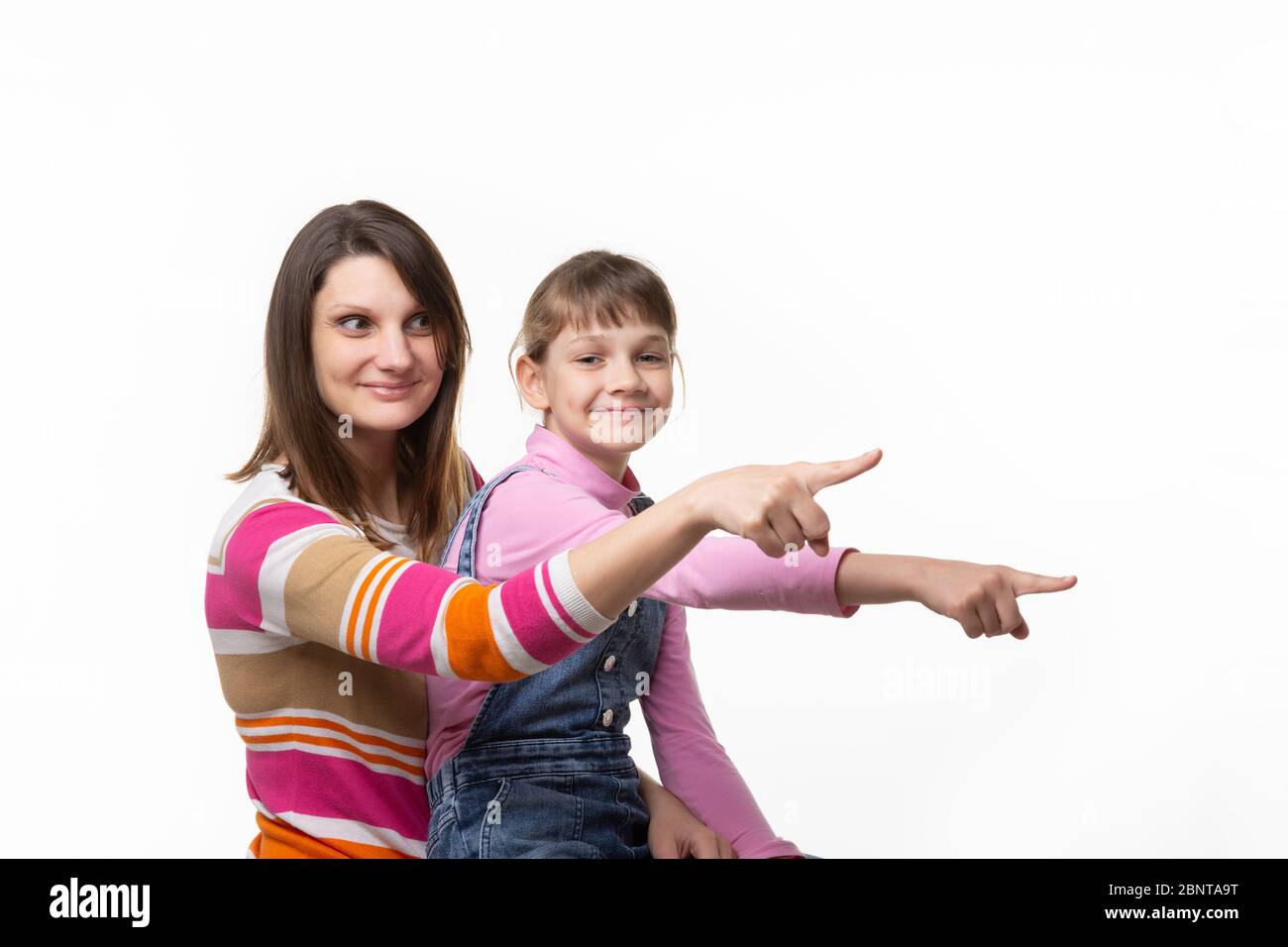 Mom and girl point a finger to an empty place Stock Photo - Alamy