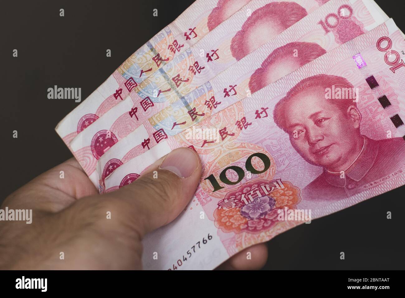 Persons hand giving the Currency of the China - One red hundred ...