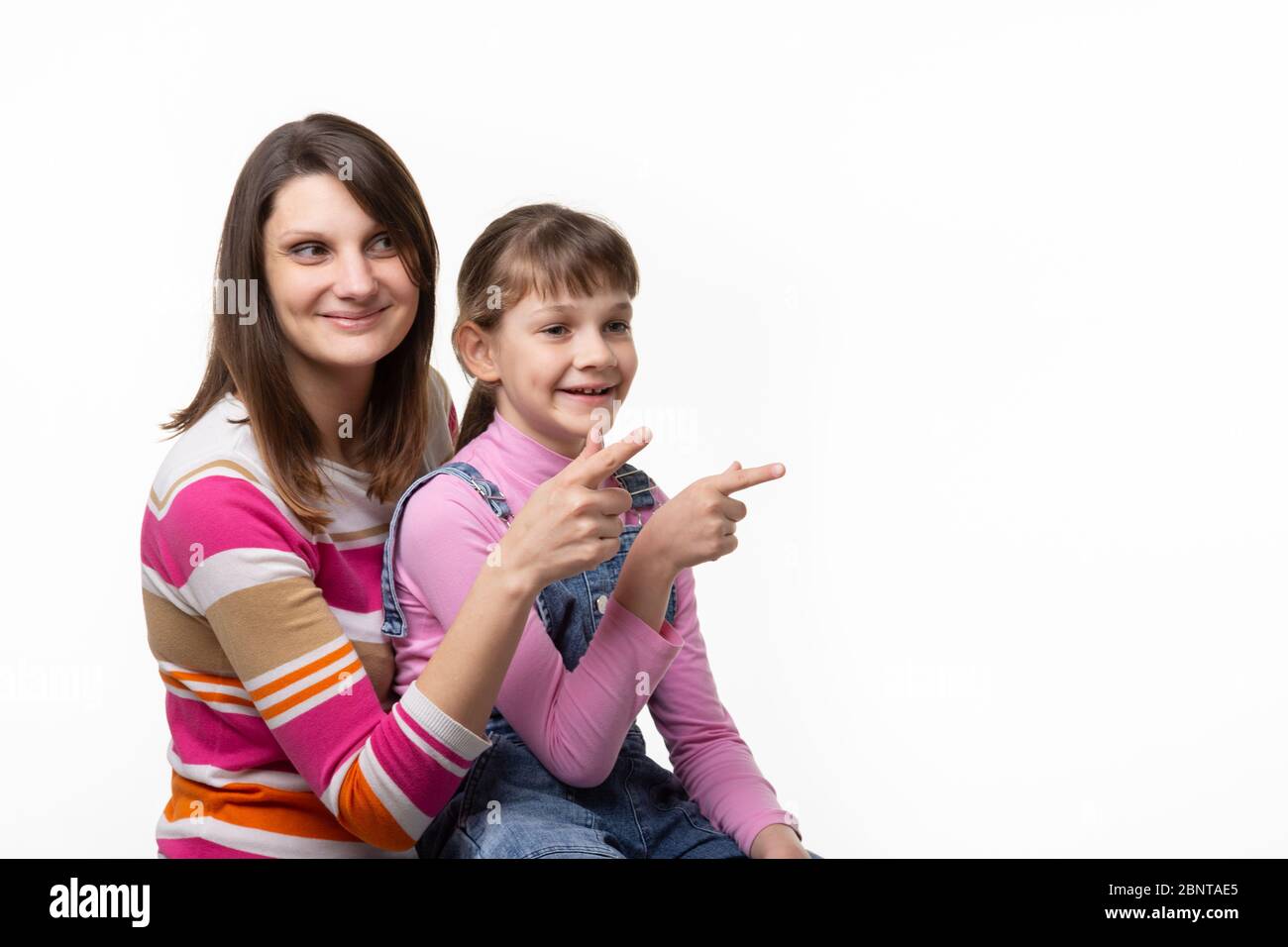 Girl Sitting On Moms Lap And Joyfully Point A Finger To An Empty Place