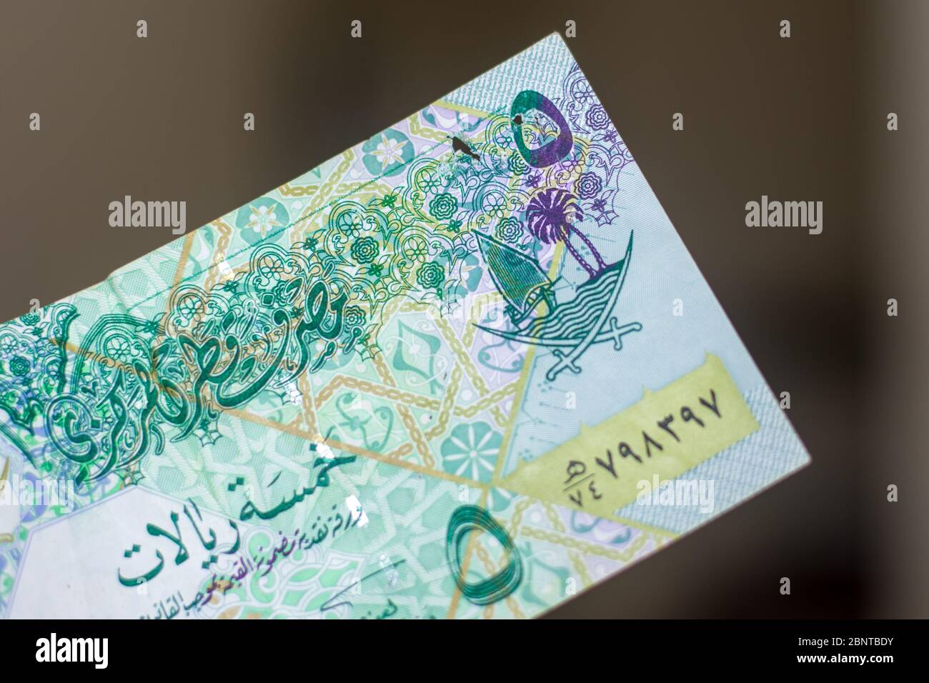 Persons hand giving the Currency of the Qatar - Green Five rial or ...