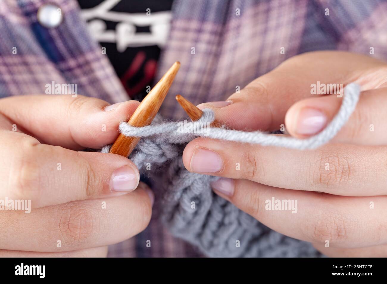 Women's hands knit from grey wool. Hand knitting Stock Photo - Alamy