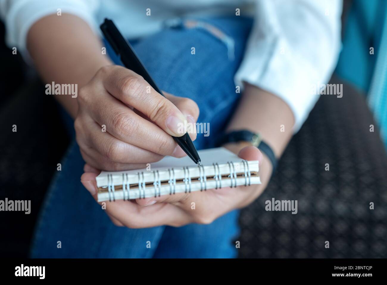 Closeup image of a woman's hands holding and writing on blank notebook ...