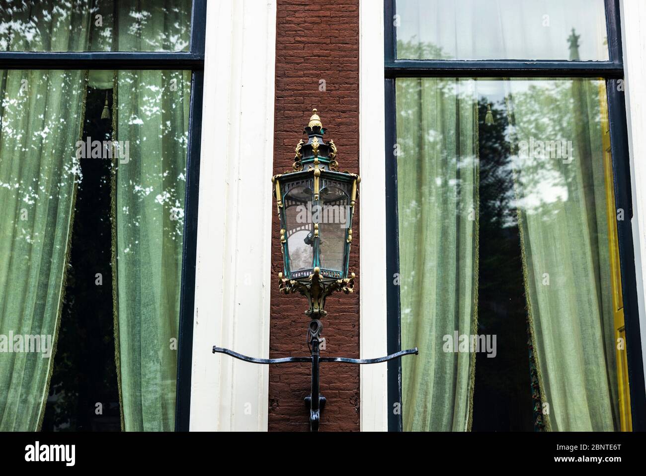 Old classic street light between two curtained windows in the old town ...