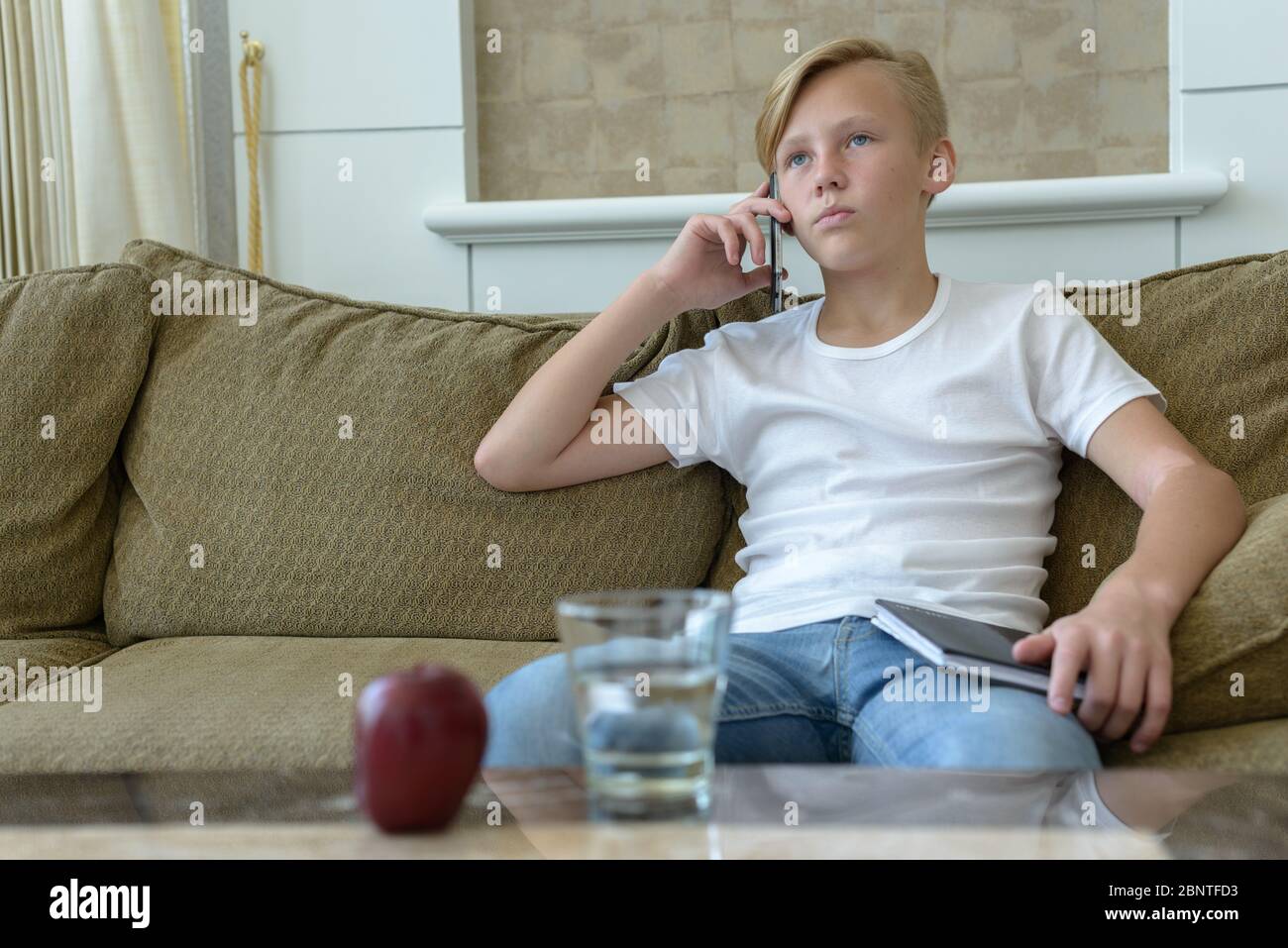 Young blond handsome boy talking on the phone at home Stock Photo - Alamy