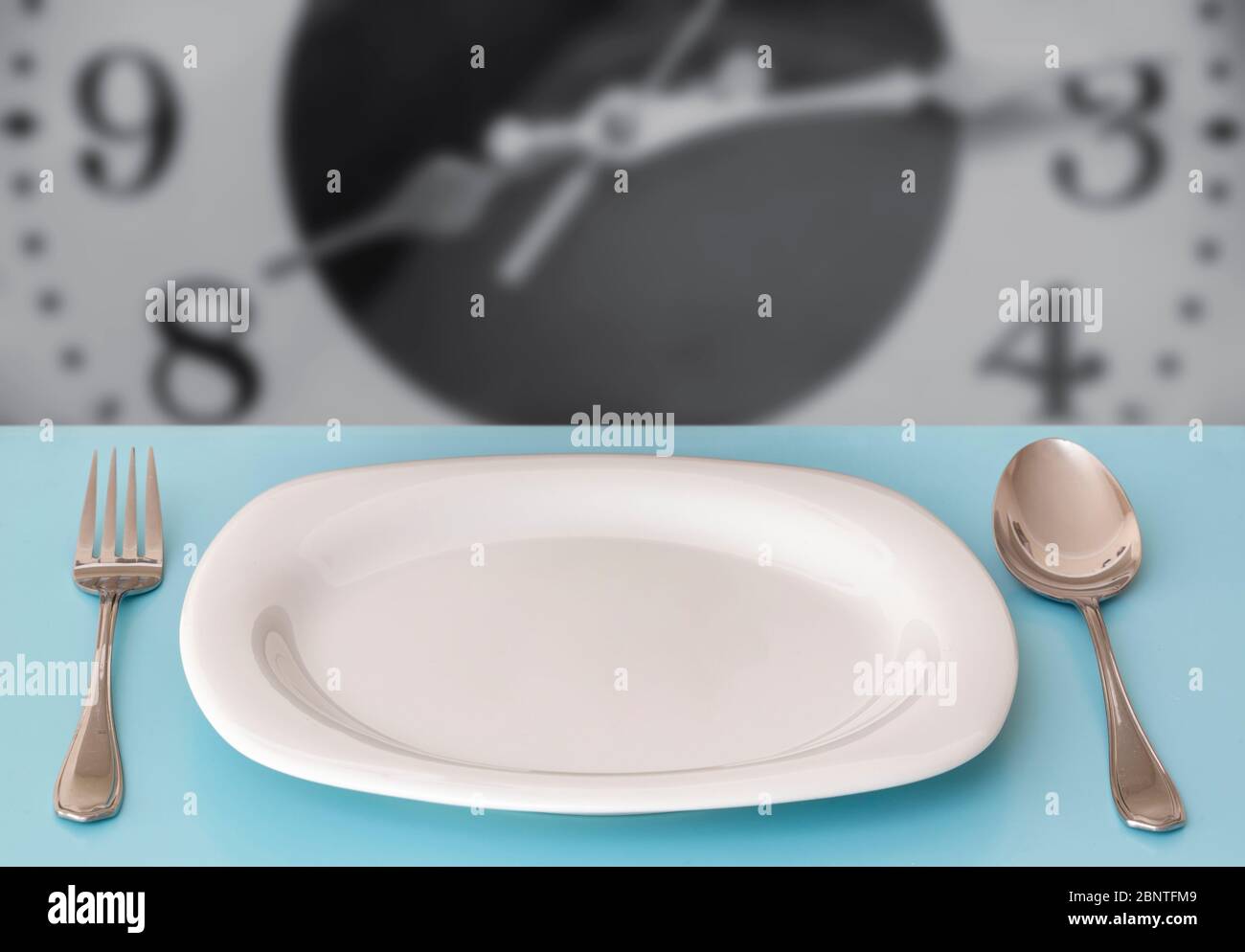 empty plate and clock concept Stock Photo - Alamy