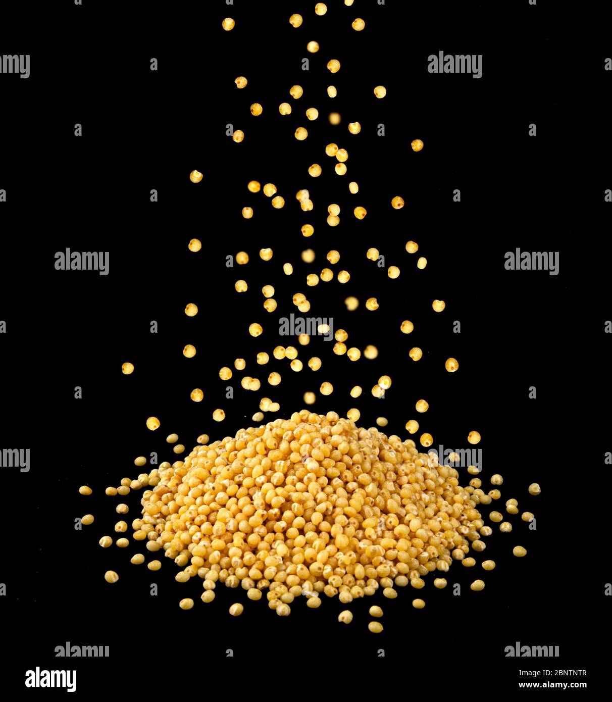 Falling dry millet grains isolated on black background Stock Photo - Alamy