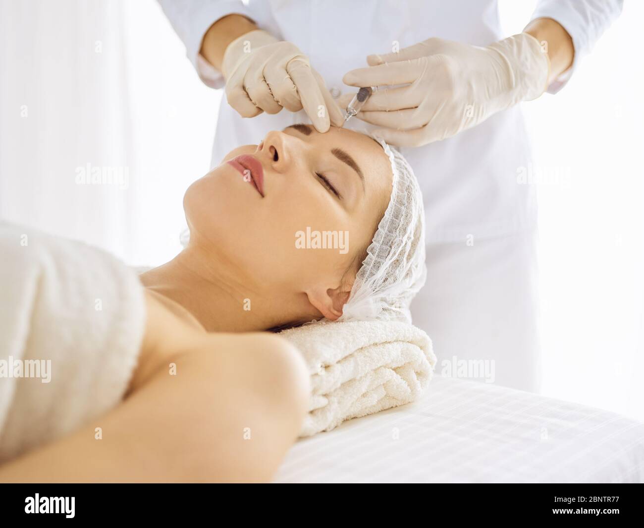 Beautiful woman receiving beauty injections with closed eyes ...