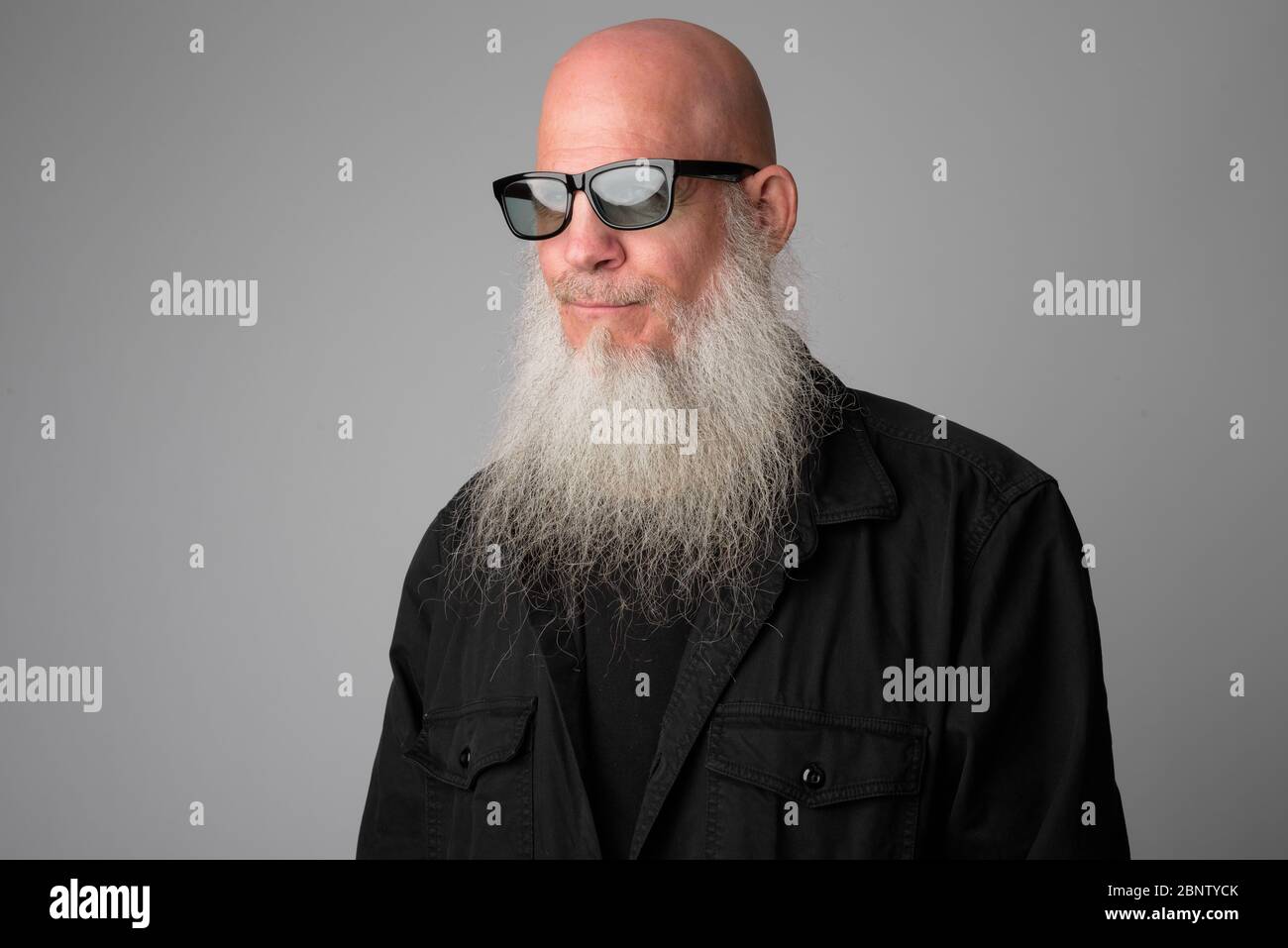 Face of mature handsome bald man with long beard thinking and wearing ...