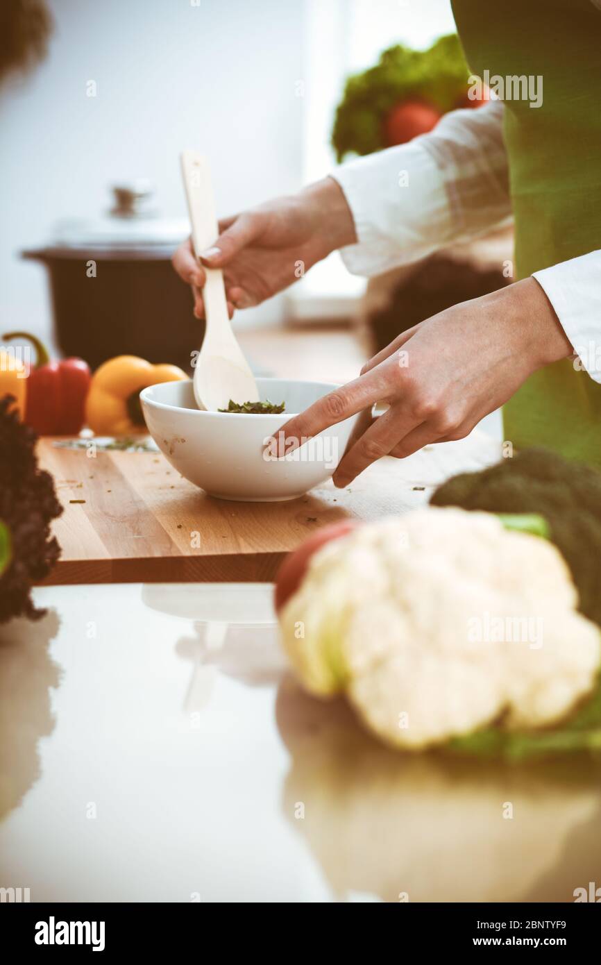 Unknown human hands cooking in kitchen. Woman is busy with vegetable ...