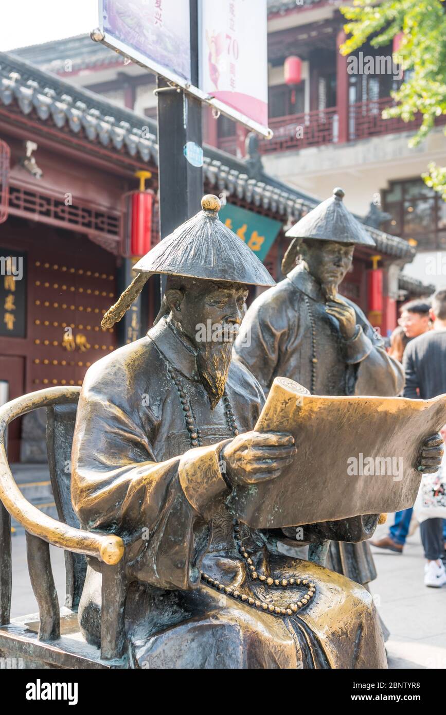Sculpture of two examiners with official robes of Qing Dynasty in front ...
