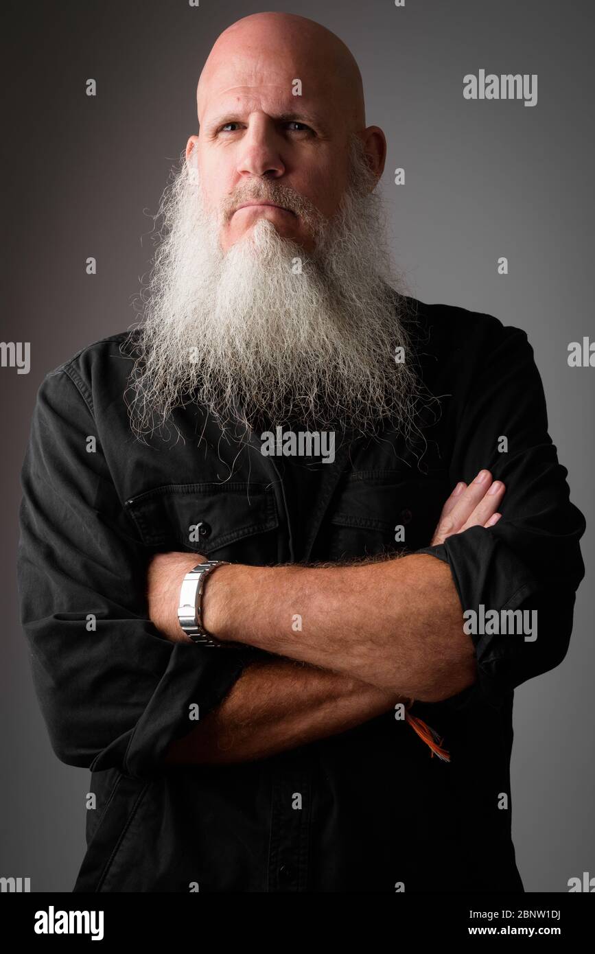 Mature handsome bald bearded man with arms crossed Stock Photo - Alamy