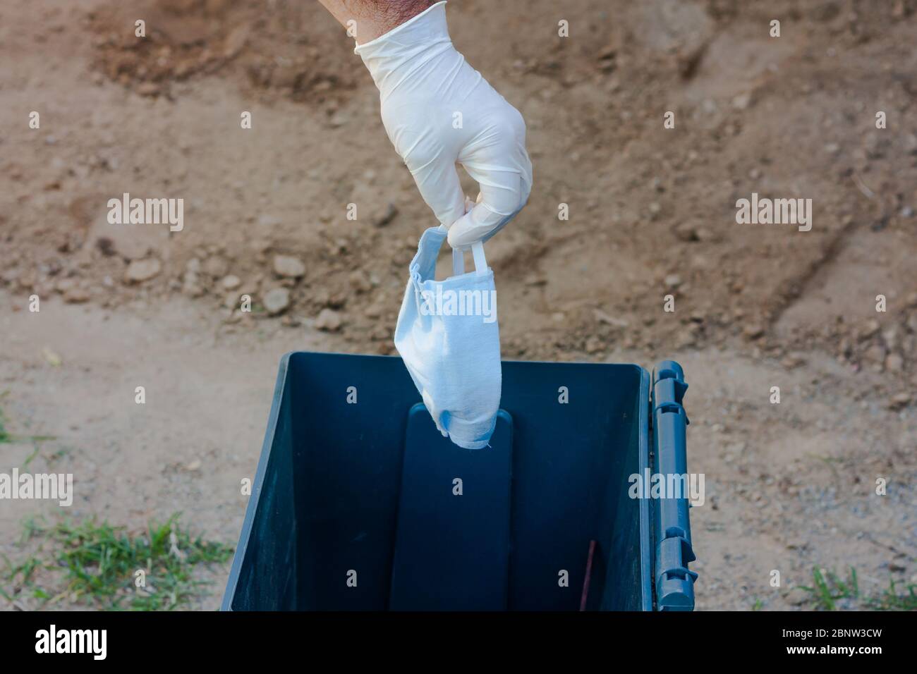 Man throwing used surgical mask into recycling bin. Waste disposal ...