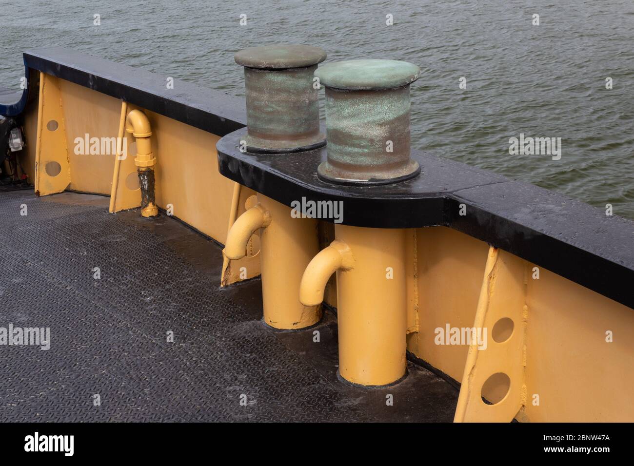 Pair of bollards mounted to the rail of a metal ship, boat details ...