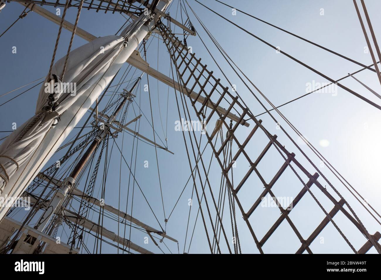 Tall ship rigging and shroud, masts and ropes against a blue sky ...