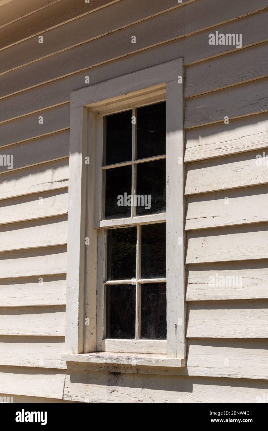 Eight pane window, four over four, in the wall of a clapboard house ...