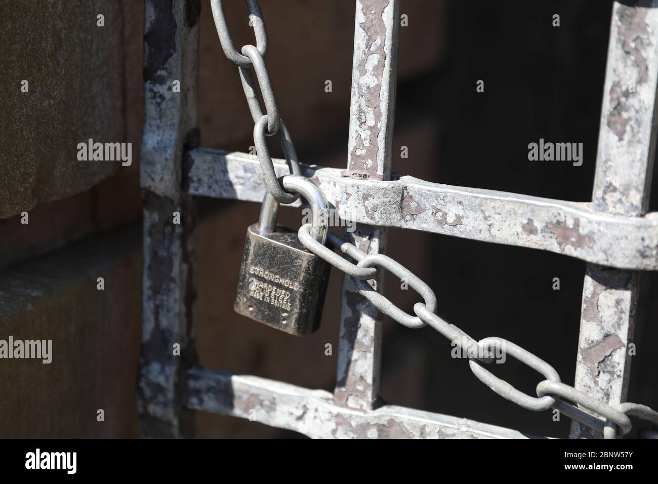 Padlock with chain over Iron gate prison Stock Photo - Alamy