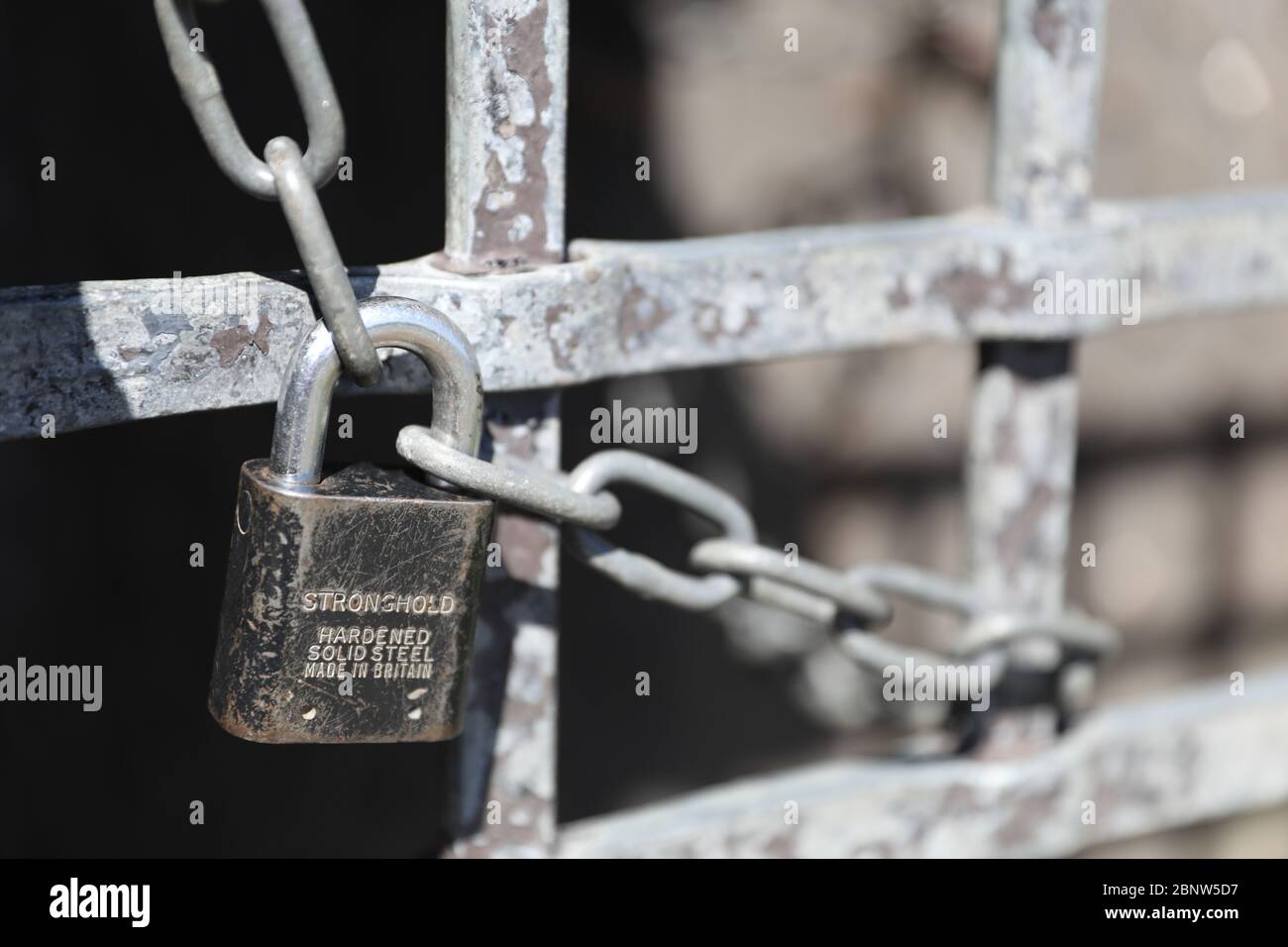 Padlock with chain over Iron gate prison Stock Photo - Alamy