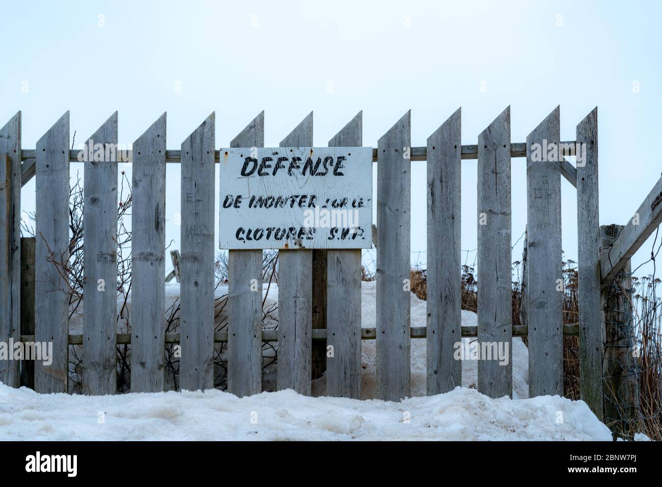 Warning sign in french on an old fence in snow Stock Photo - Alamy