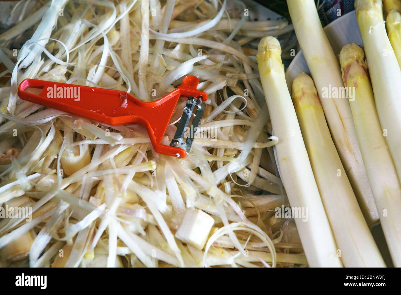 close-up of asparagus and its peel and red cutter Stock Photo - Alamy