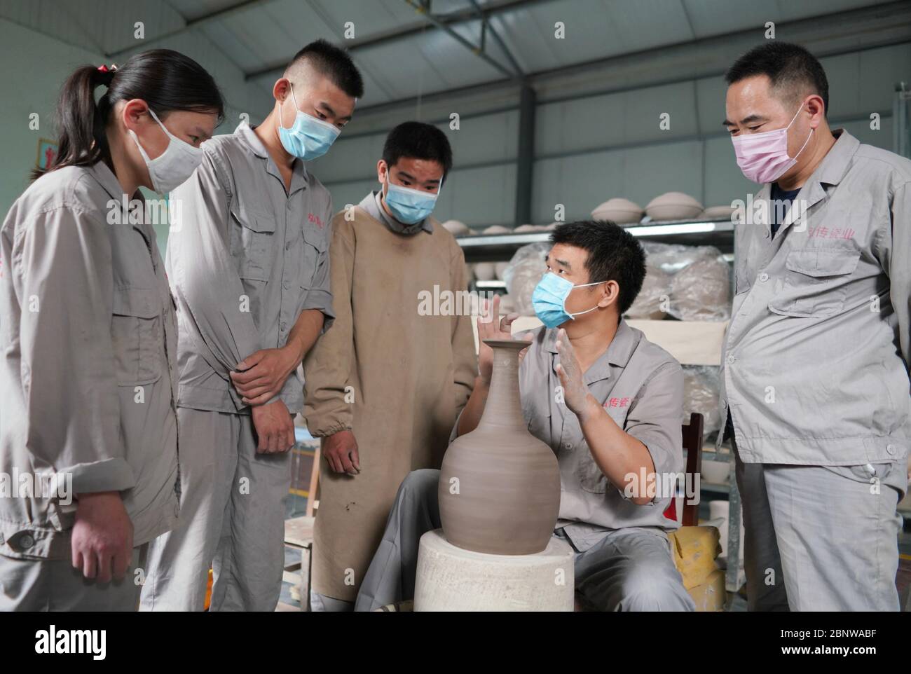 Geng Huimin (2nd R) teaches disabled apprentices the making techniques ...