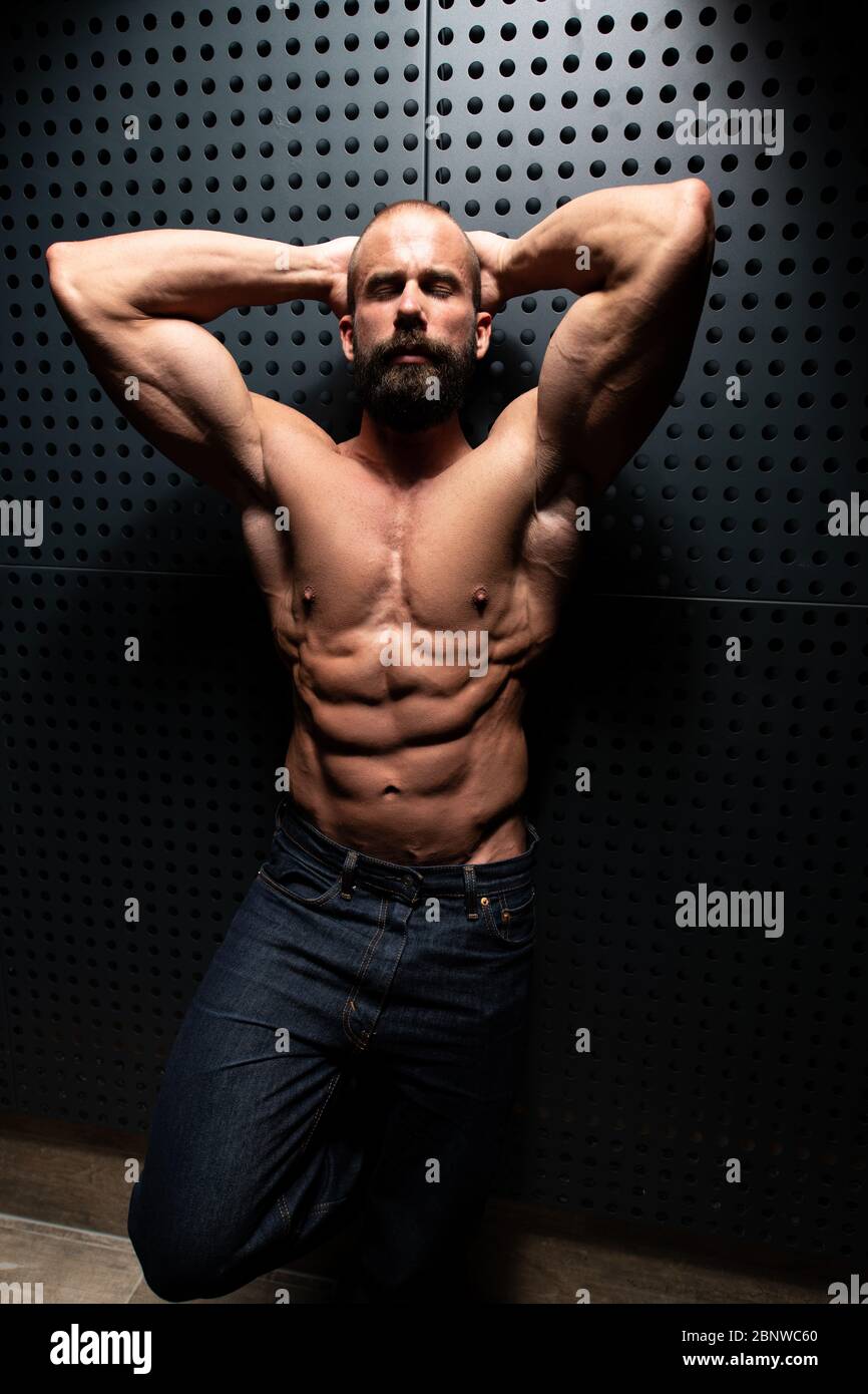 Healthy Young Man Standing Strong Standing Against a Wall and Flexing ...