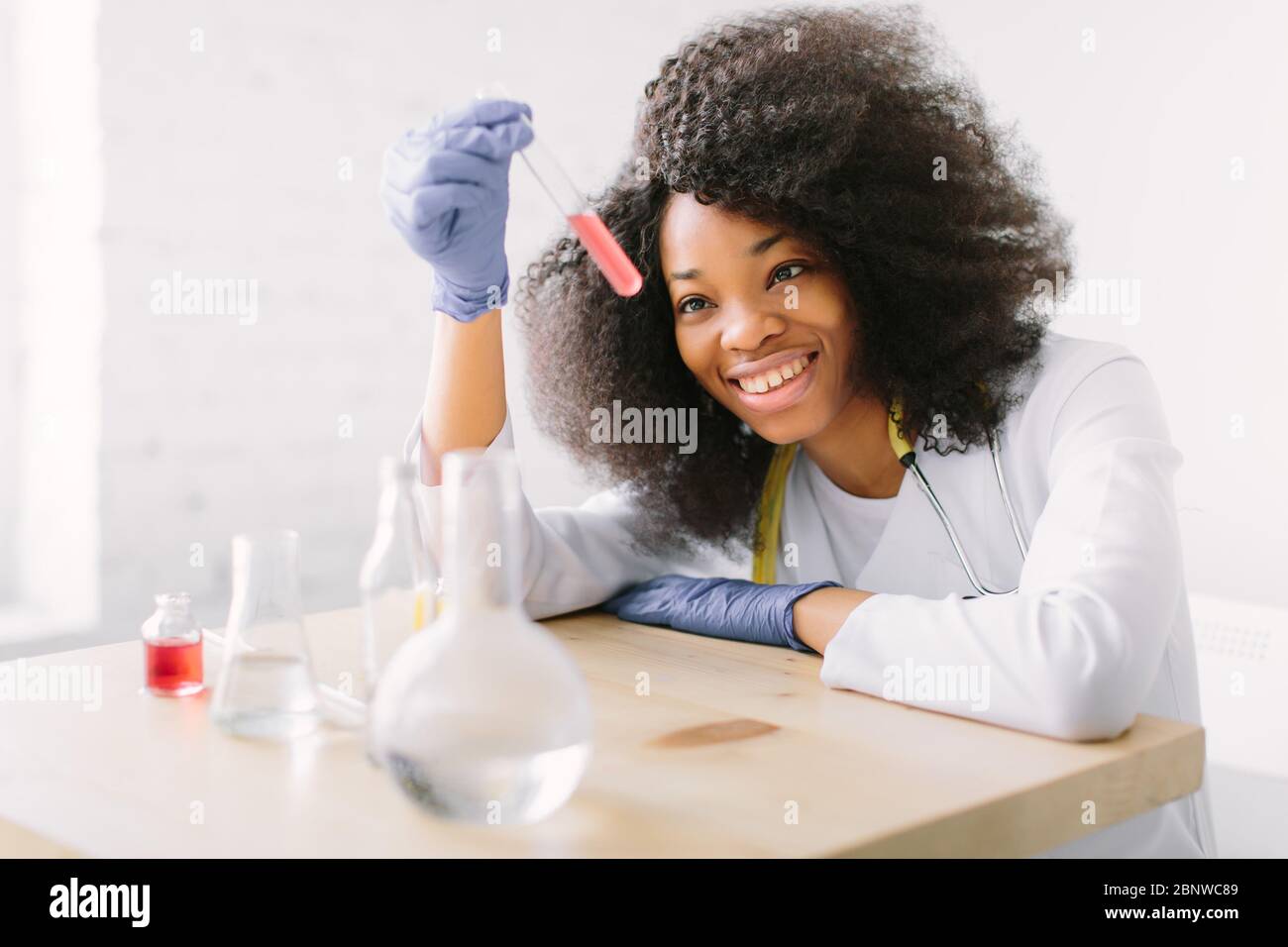 Young beautiful African American girl doctor in a white coat with a ...