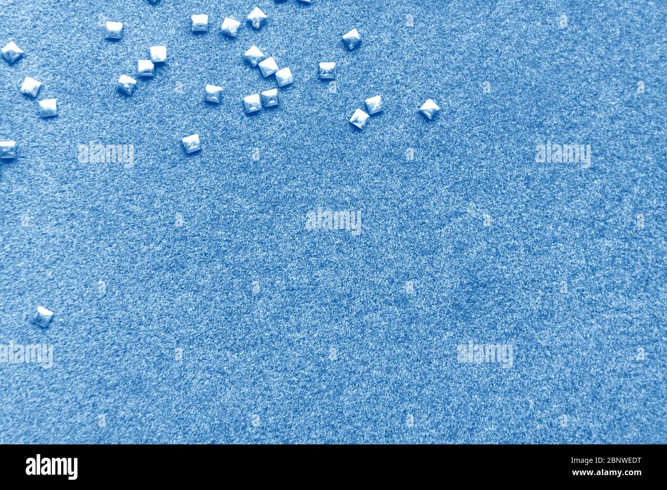 Blue paper background with shiny square beads. Glitters scattered on ...