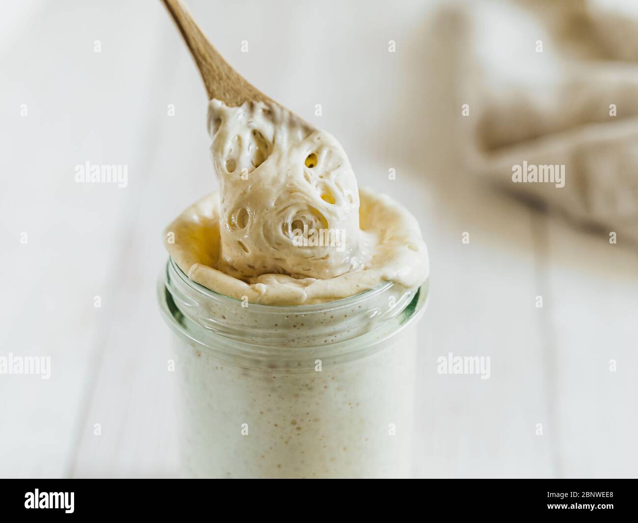 Ready for making bread wheat sourdough starter dripping from wooden ...