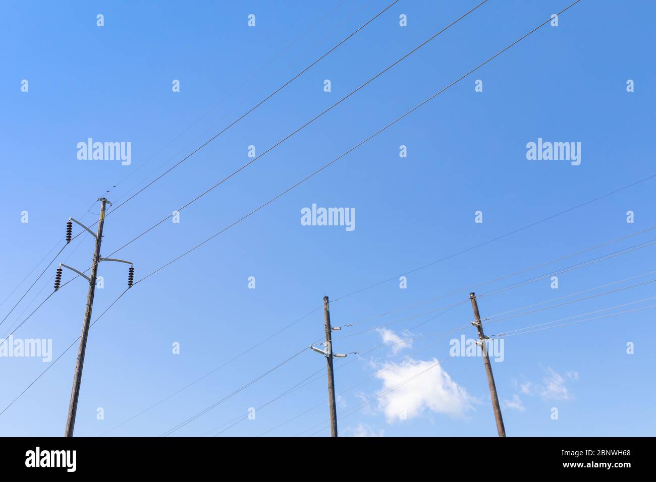Three electrical power poles side by side, strain insulators, against a ...