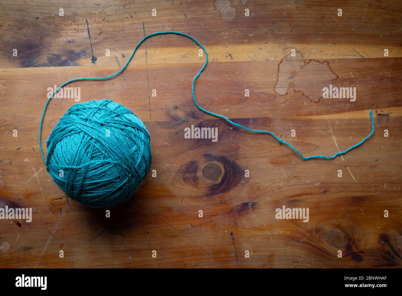 Ball of colorful aqua spun wool yarn with trailing string on a vintage ...