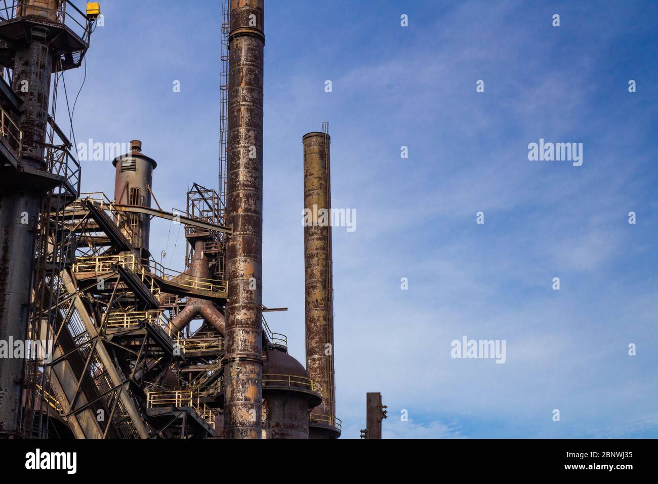 Vast steel mill complex now derelict, smoke stacks and furnaces, blue ...