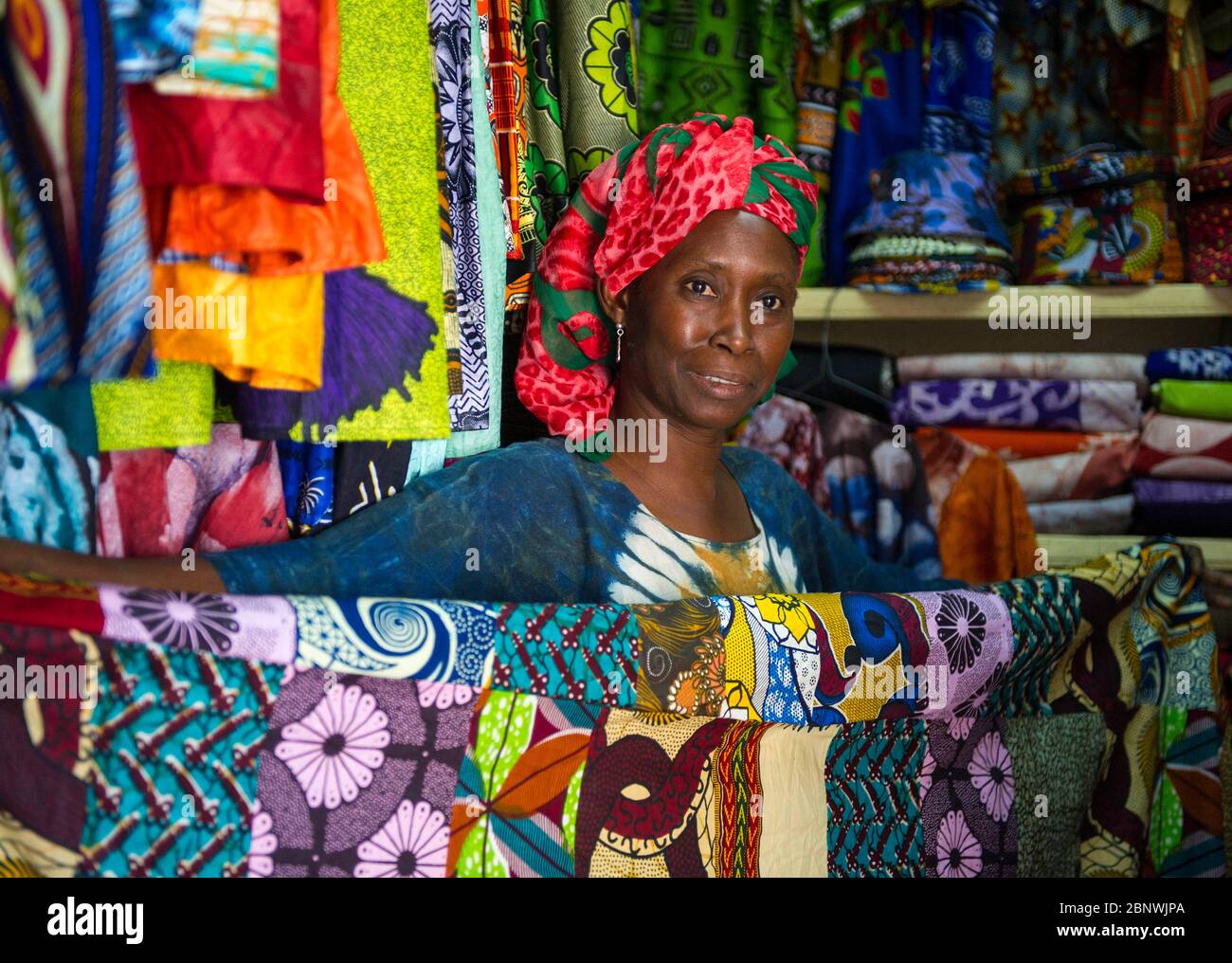 Senegalese woman poses for a picture at her fabric stall in Dakar ...