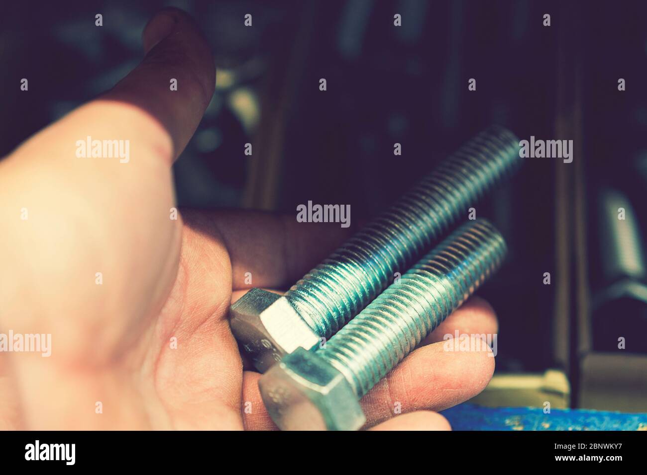 hand holds an iron bolt. repair concept. close-up Stock Photo - Alamy