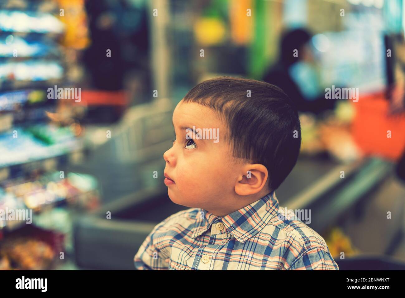 The little boy on a background of cash in a supermarket. toned Stock ...
