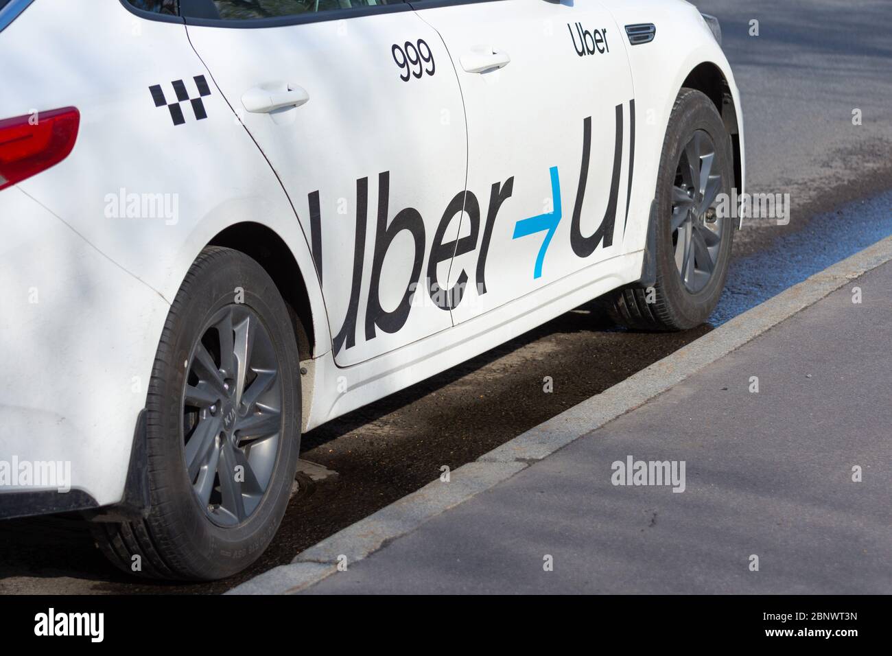 White passenger car Uber Taxi rides on the highway aerial view. Russia ...