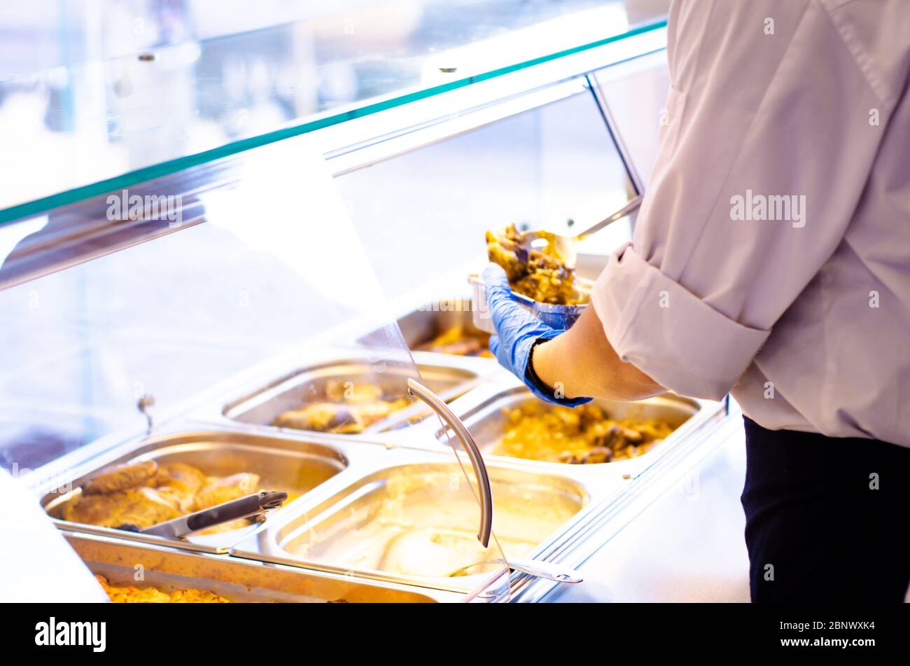 chef with blue gloves serves food in food containers Stock Photo - Alamy