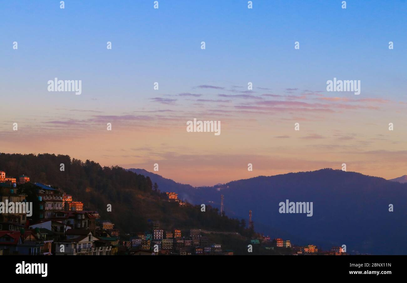 Sunset landscape in Shimla where only the upper houses and clouds ...