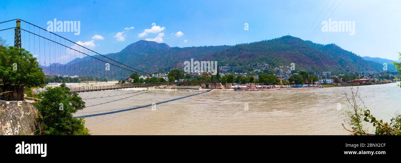 A Suspension Bridge connecting city ends over a river. The city is ...