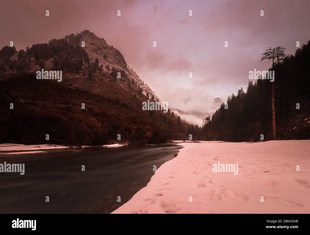 Amazing view of sunset at the snow covered Parvati river, India along ...