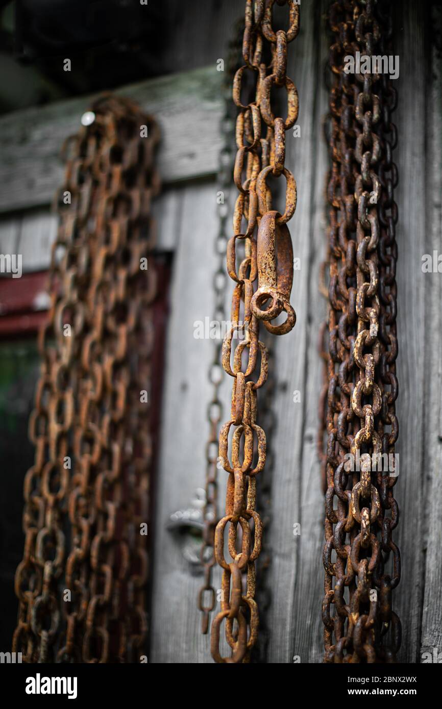 rusty iron chains hanging from the outside wall of a barn Stock Photo ...