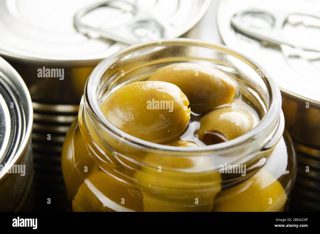 Canned green olives in just opened glass mason jar. Non-perishable food ...