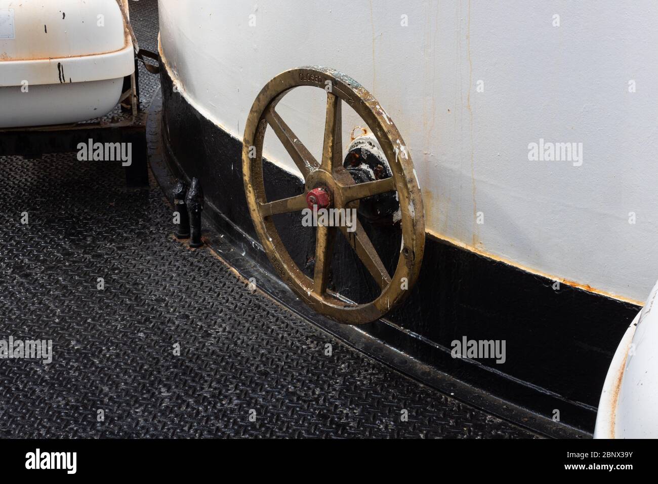 Brass valve wheel on a tank bottom, diamond plate decking, horizontal ...