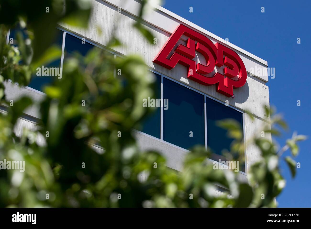 A logo sign outside of a facility occupied by Automatic Data Processing ...