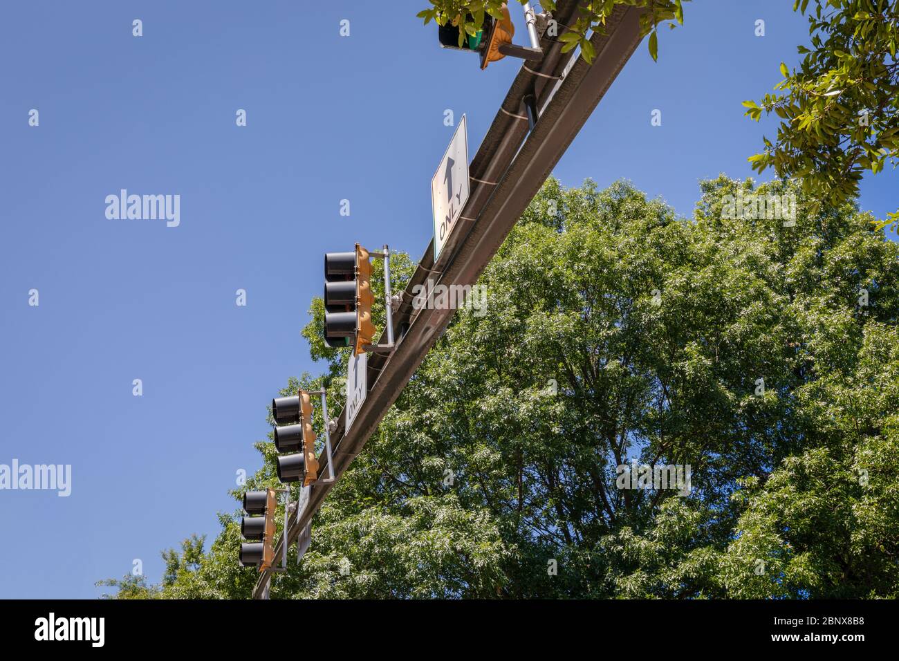 View of overhead traffic signal lights on an extension arm, blue sky ...