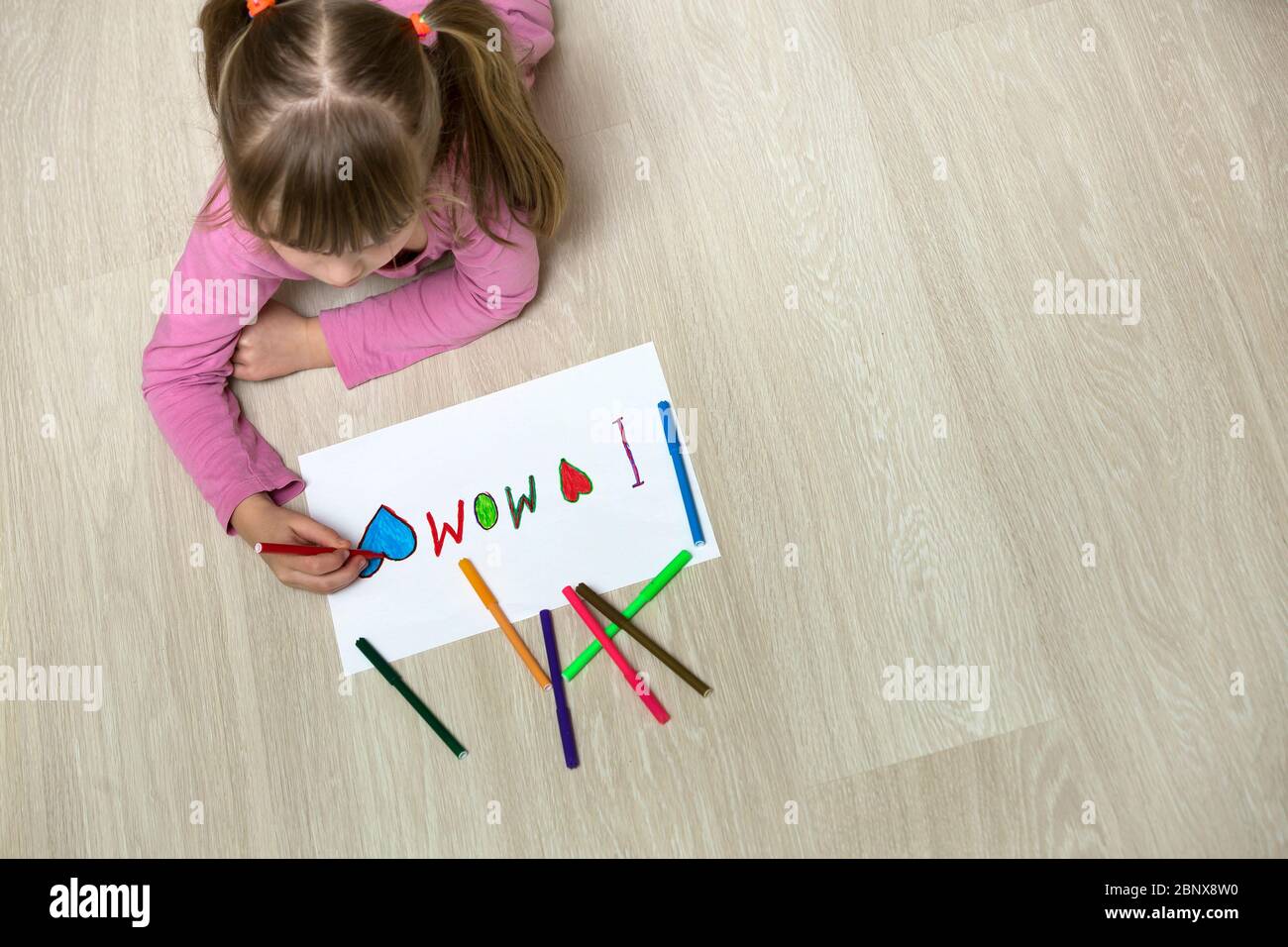 View from above of cute child girl drawing with colorful crayons I love ...