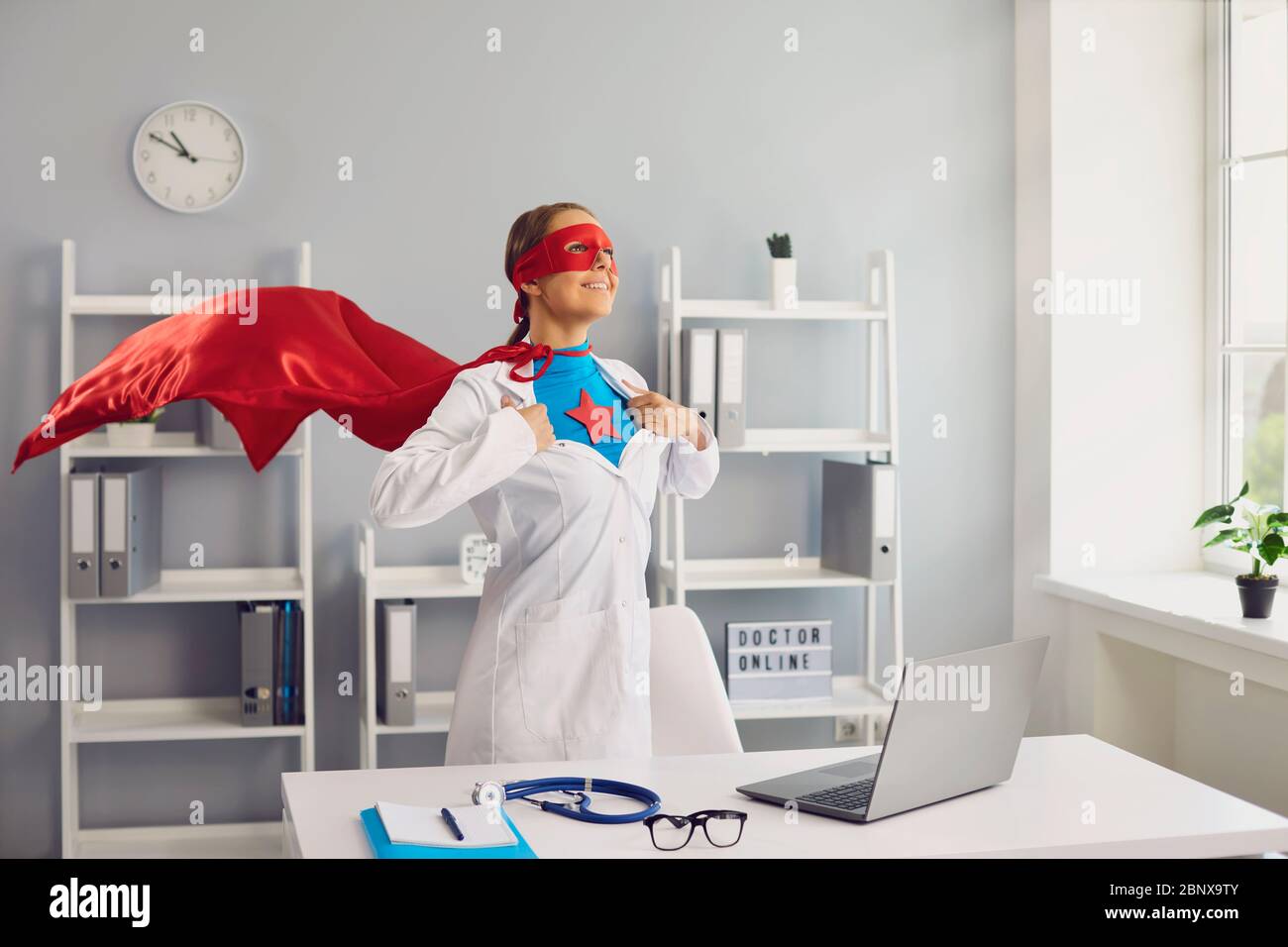 Confident female doctor superhero in a hospital office. Medical ...