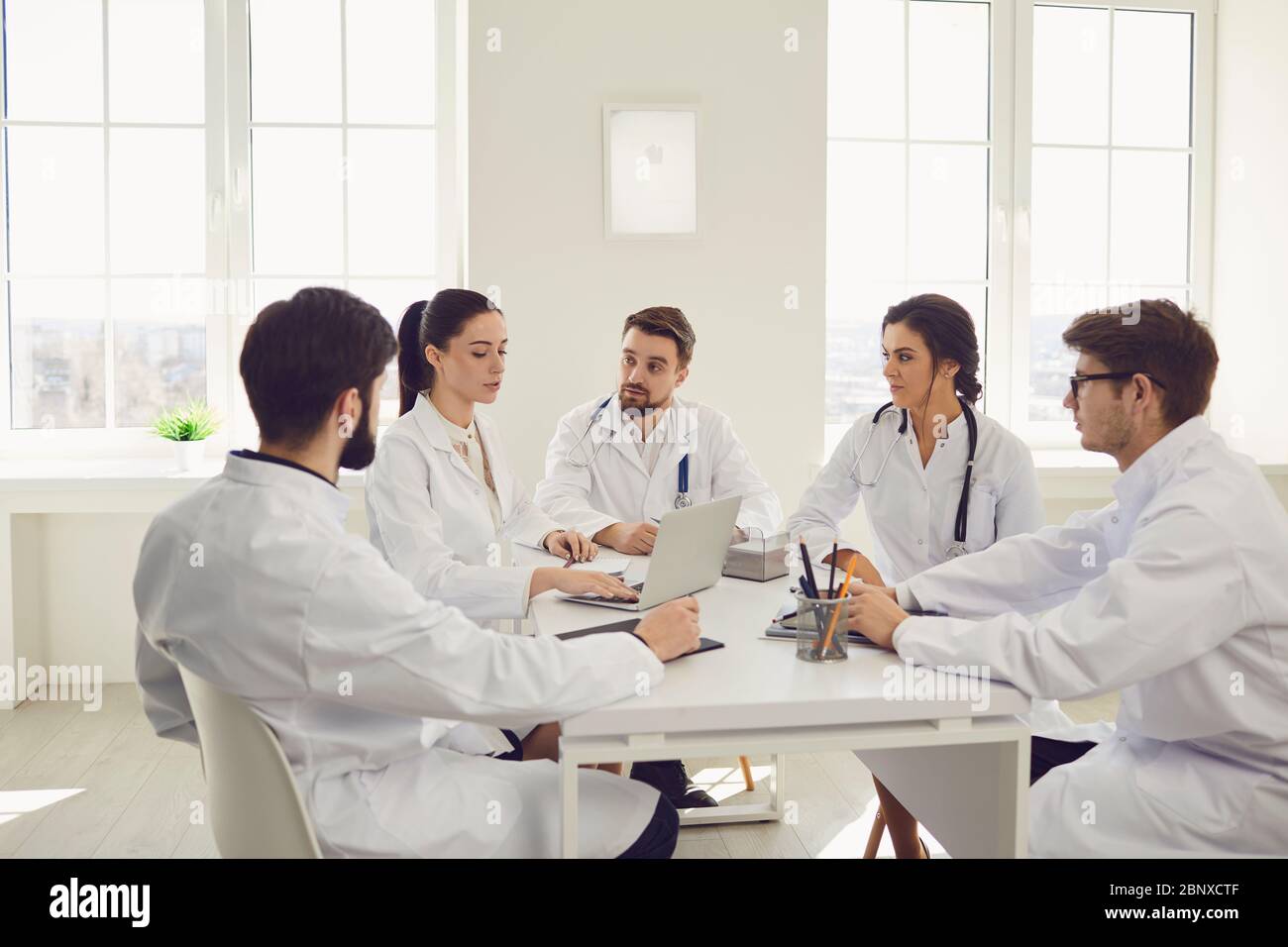 Group of doctors talking sitting at a table in the office of the ...