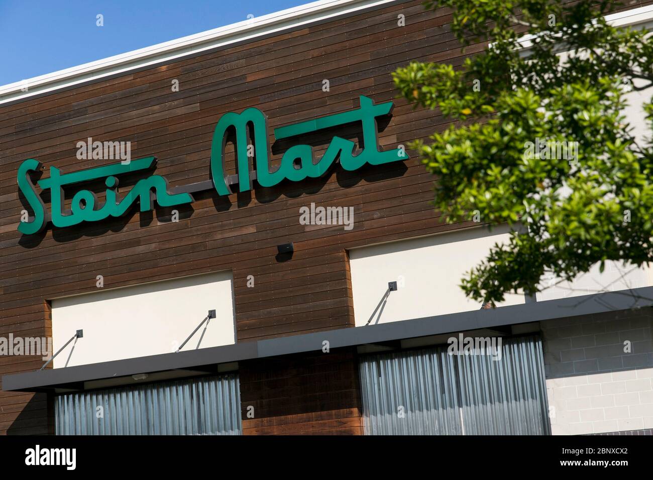 A logo sign outside of a Stein Mart retail store location in Newport ...